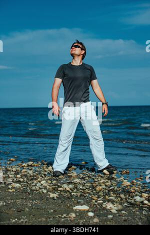 Smiling young black man waves hand at videocall on smartphone sitting ...