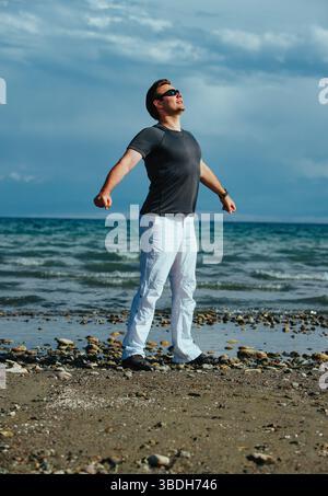 Smiling young black man waves hand at videocall on smartphone sitting ...