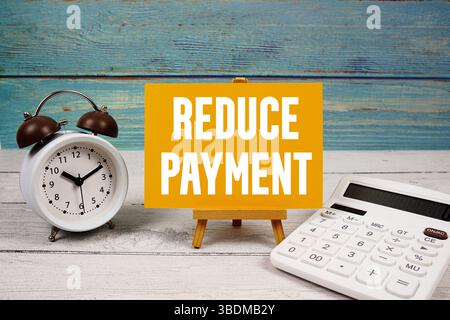 Reduce payment text on card on wooden background. business concept ...