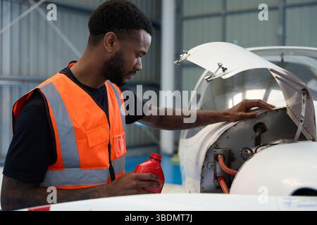 Aircraft mechanic performing maintenance on engine in hangar Stock ...