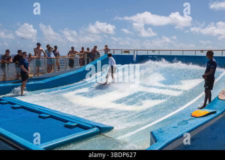 Woman surfing at the Flowrider activity on the Royal Caribbean Allure ...