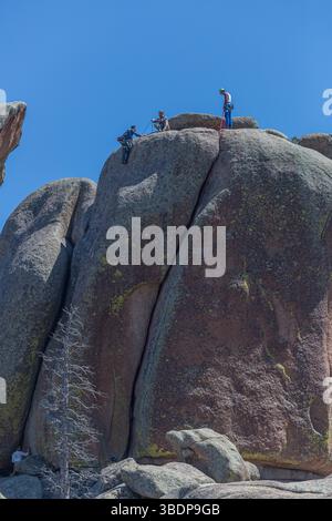 Men rock climbing on a large granite boulder in the Vedauwoo Recreation ...