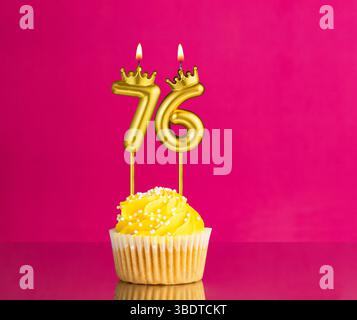 Number 76 gold celebration candle and small stars in sweet cupcake on ...
