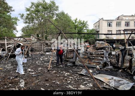 People stay by cars destroyed by an overnight Russian drone strike in ...