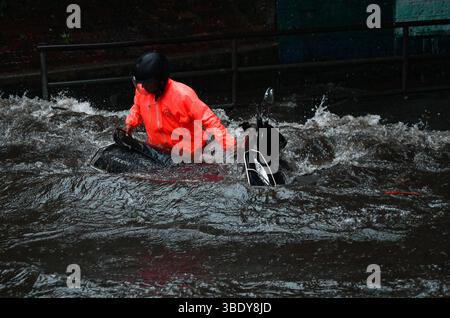 MUMBAI, INDIA - MAY 26: A biker stuck in a waterlogged road at Gandhi Market in the Sion area ...