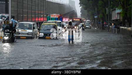 MUMBAI, INDIA - MAY 26: Vehicles wade through waterlogged road at Gandhi Market in the Sion area ...