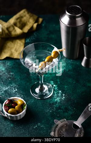 Traditional martini cocktail with olives garnish and charcuterie board ...