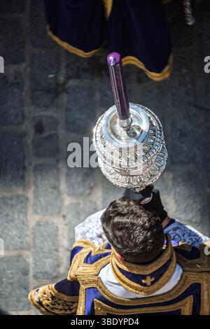 An acolyte walks through the streets of Seville, carrying a decorated ...