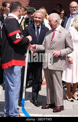 Prime Minister Mark Carney, centre, tours Bombardier flanked by company ...
