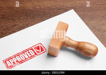 Sheet of paper with red stamp Approved, passport and wooden stamp on ...