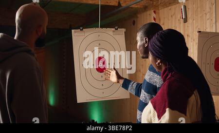 Shooting gallery safety officer explaining bullseye scoring system and ...