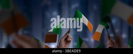 Ireland flags in their hands on a blurred urban background Stock Photo ...