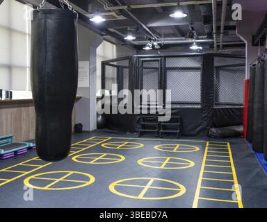 An octagonal kickboxing cage with boxing bags in the sports complex ...