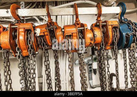 Chain hoists for lifting weights in a workshop close-up Stock Photo - Alamy
