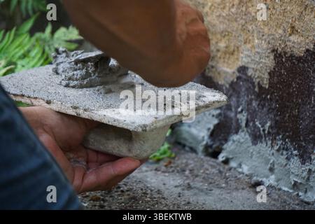 Cement mortar being applied during construction work, with visible ...