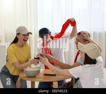 Emotional sports fans with drinks celebrating victory indoors Stock ...