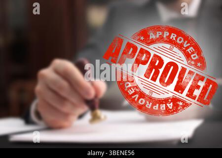 Man stamping document at table and red stamp Approved Stock Photo - Alamy