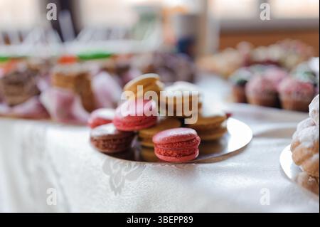 Closeup of pastel macaroons platter on elegant dinner table decorated ...