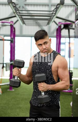 A weightlifting athlete focuses on lifting heavy weights in a gym. The ...