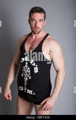 Man wearing oversized stringer vest and flexing his biceps Stock Photo ...