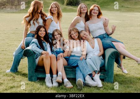 Generation z university students posing on green sofa outdoors Stock ...