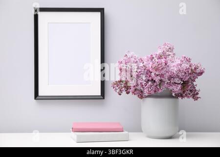 Vase with lilac flowers and blank frame on windowsill Stock Photo - Alamy