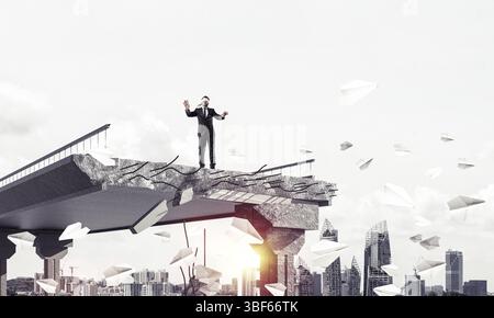 Businessman walking blindfolded on concrete bridge with huge gap as ...