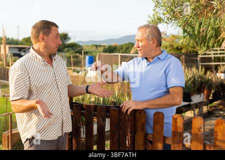 Neighbors arguing at fence outdoors Stock Photo - Alamy