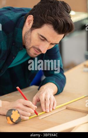 Carpenter marking measurements on piece of wooden board Stock Photo - Alamy