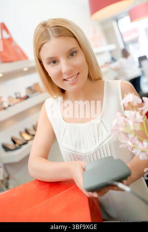 Lady using card machine at checkout Stock Photo - Alamy