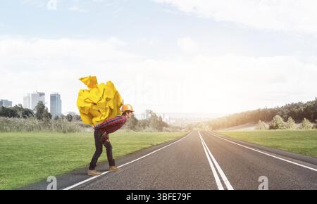 Builder man carrying paper ball on his back Stock Photo - Alamy