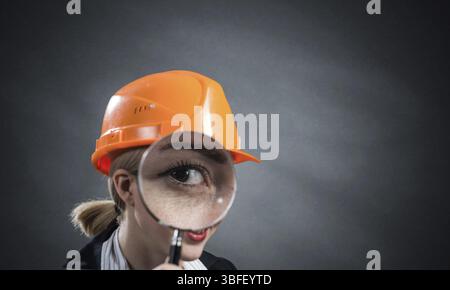 Technical inspector looking through magnifying glass. Woman civil ...