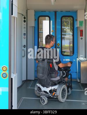 Wheelchair user using accessible train travel waits at a station for ...