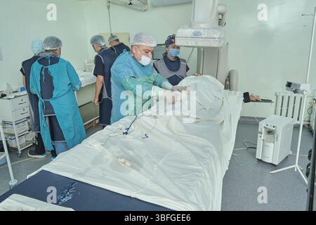 Doctors perform cardiac catheterization, inserting a thin catheter ...