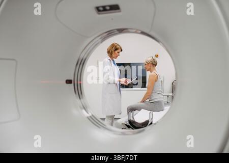 Doctor sharing positive CT scan results with smiling patient in imaging ...