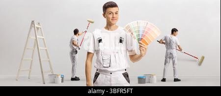 Young mail painter holding a color swatch palette and pointing up ...