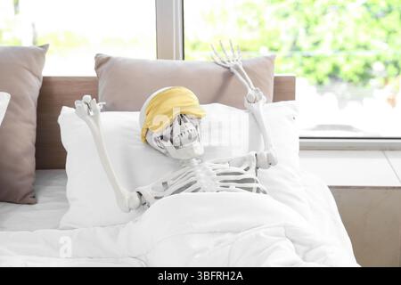 Human skeleton with sleeping mask lying in bedroom Stock Photo - Alamy