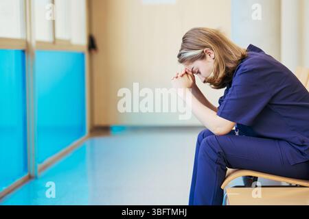 Female nurse feeling exhausted and stressed in her vehicle after a long ...