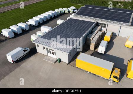 Delivery vans and trucks hub with solar panels on a roof. Fleet of ...