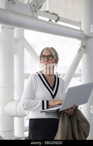 Woman in glasses hold laptop and businesscard Stock Photo - Alamy