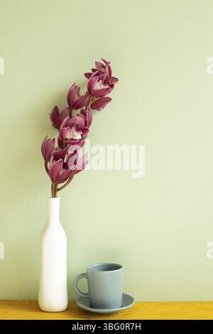 Vase of cymbidium flower on wooden table. green background Stock Photo ...
