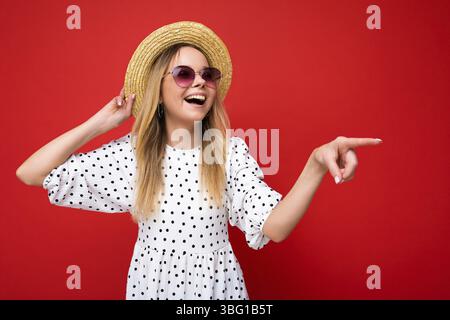 Portrait of beautiful fascinating female promoter pointing to the side ...