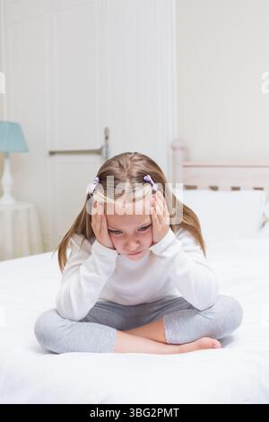 Upset girl sitting at table in auditorium during break on background ...