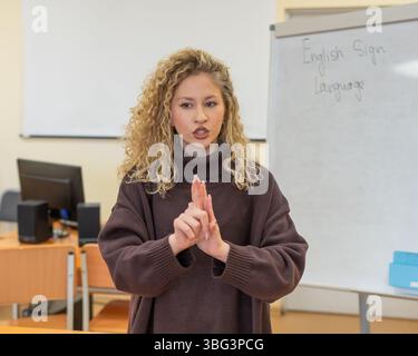 Caucasian female teacher communicates in Russian sign language with ...