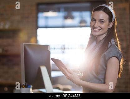 Smiling woman at desk in a loft Stock Photo - Alamy