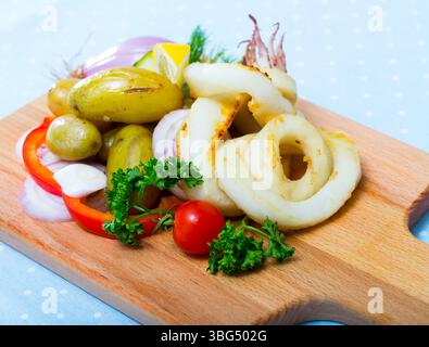 Squid rings with potatoes and fresh vegetables and herbs served at ...