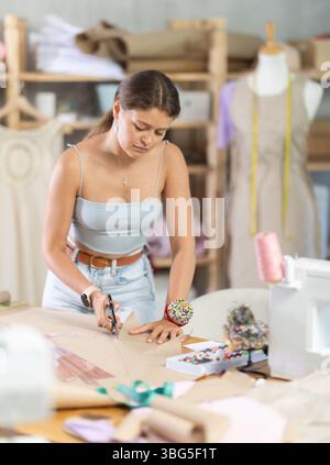 Female fashion designer cutting paper Stock Photo - Alamy