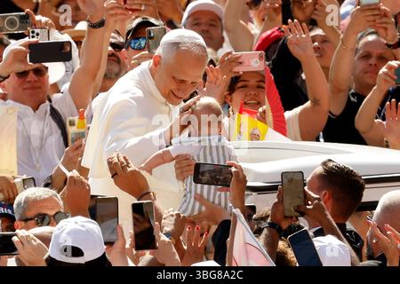 Pope Leo XIV caresses a baby as he arrives at the Pavia's Cathedral ...