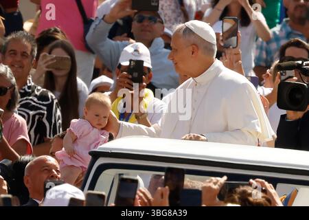 Pope Leo XIV caresses a baby as he arrives at the Pavia's Cathedral ...