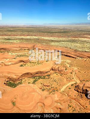 Aerial view of red, eroded canyon landscape with sparse green ...